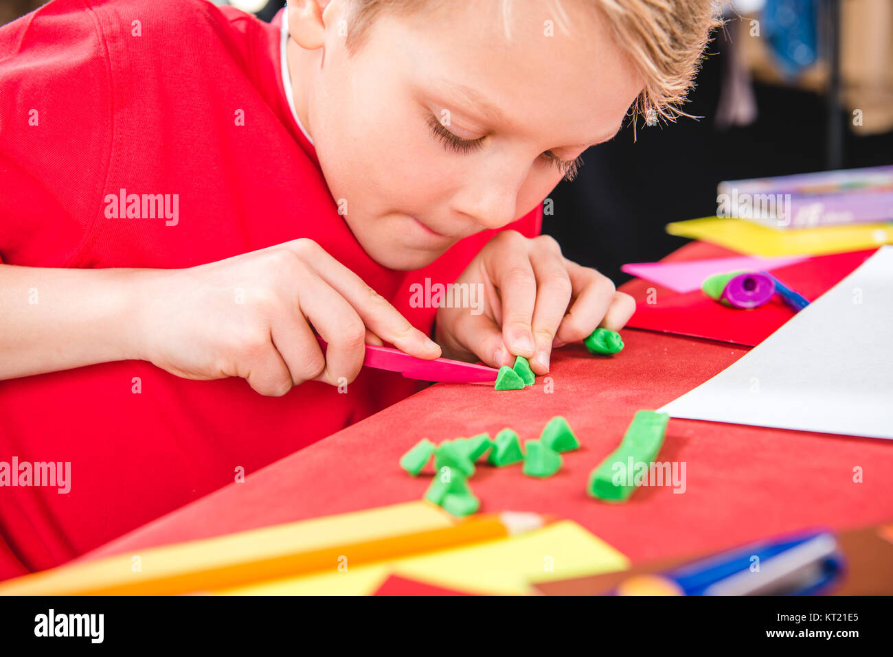Schoolchild cutting plasticine Stock Photo - Alamy