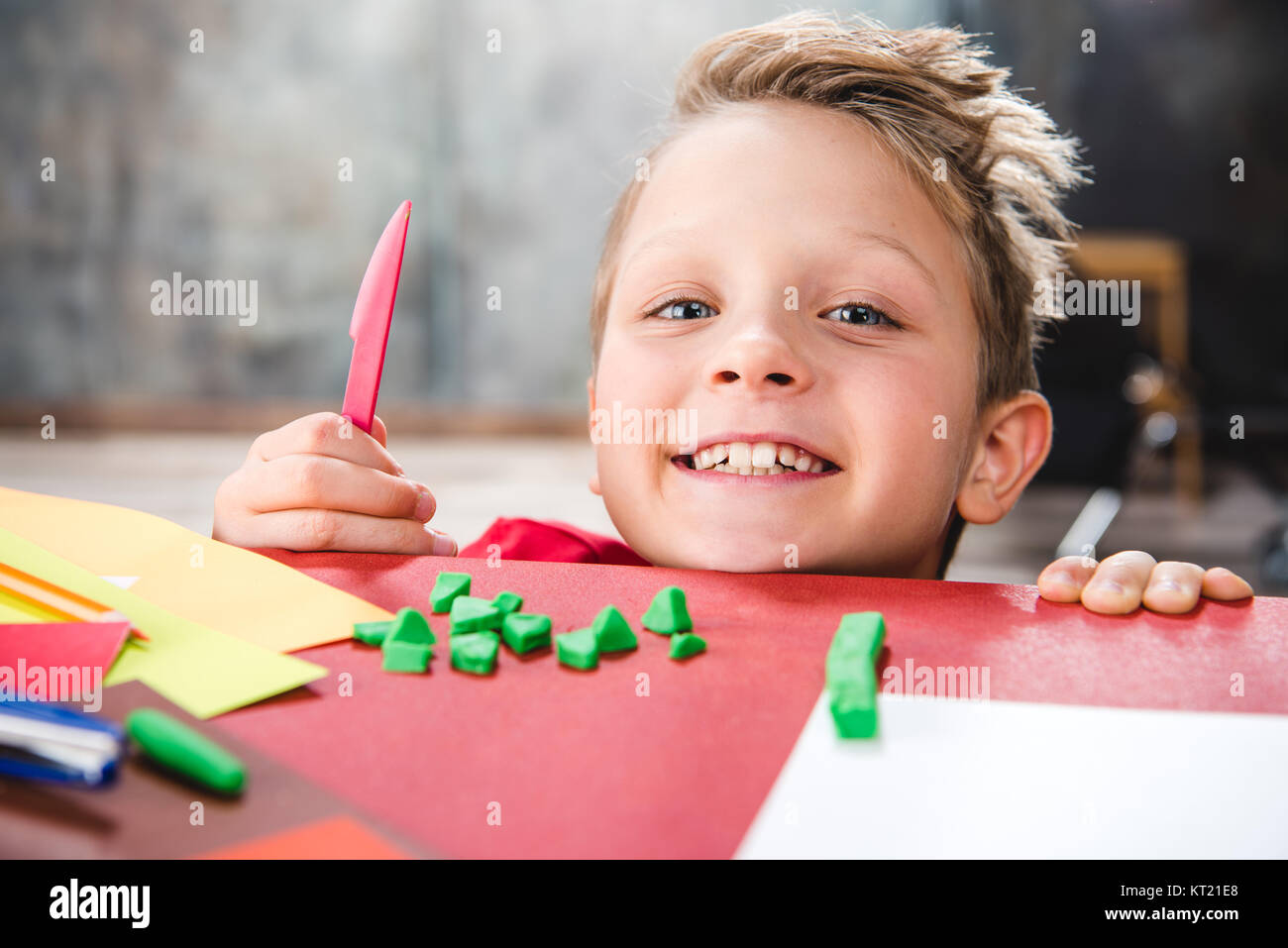 Schoolchild cutting plasticine Stock Photo - Alamy