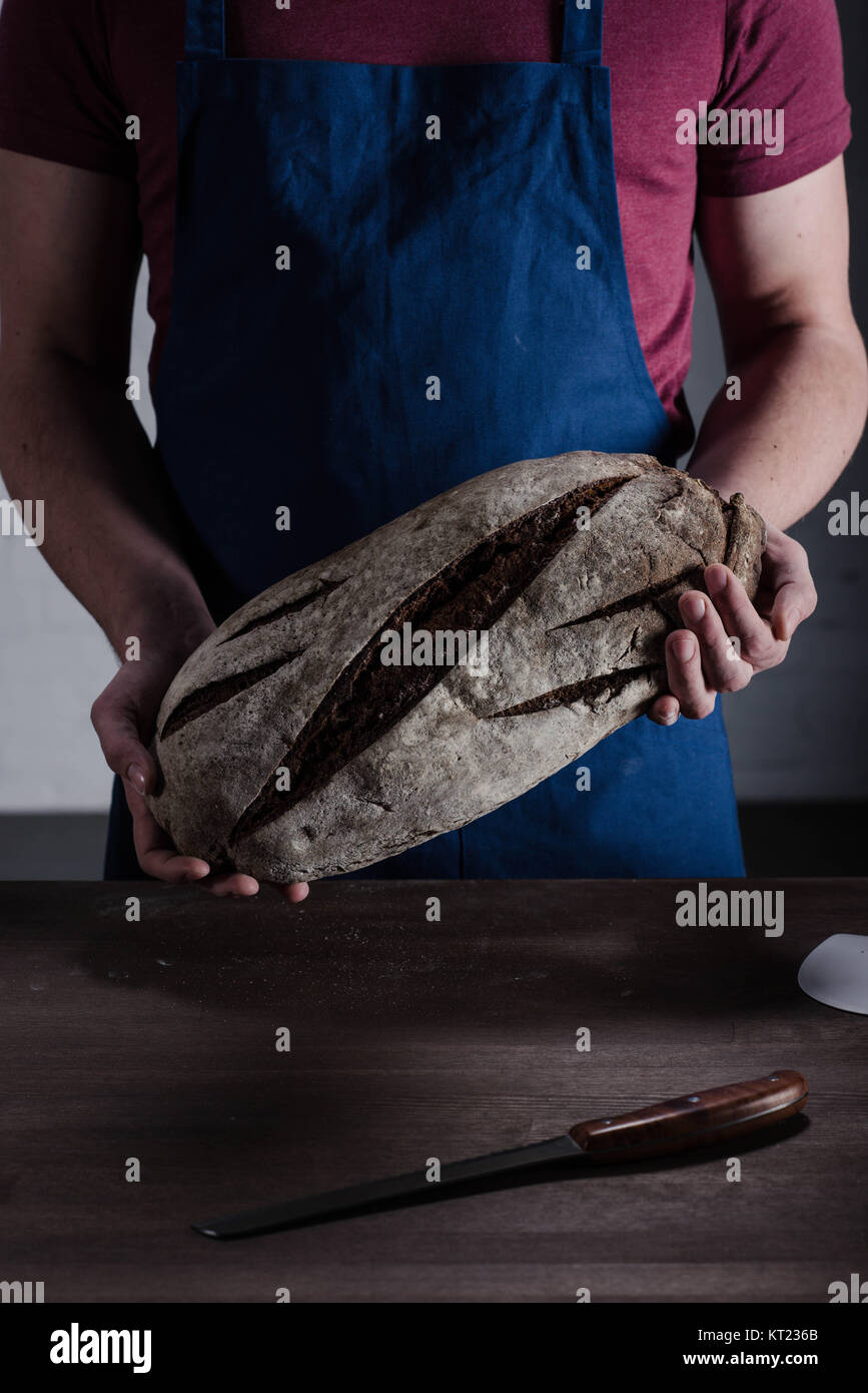 Baker holding bread Stock Photo - Alamy