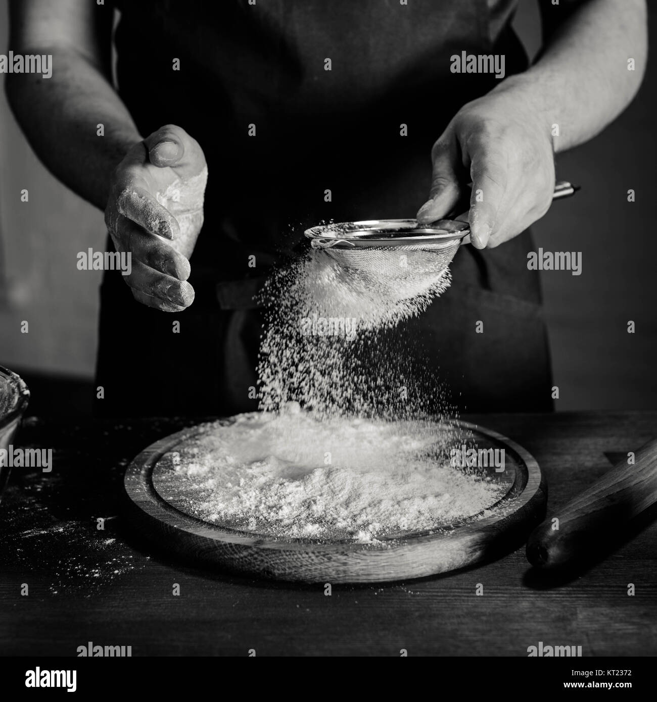 Baker sifting flour Stock Photo - Alamy