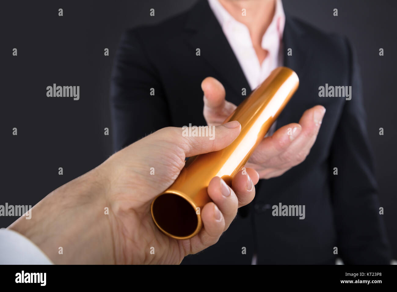 Businessman Passing A Golden Relay Baton Stock Photo - Alamy
