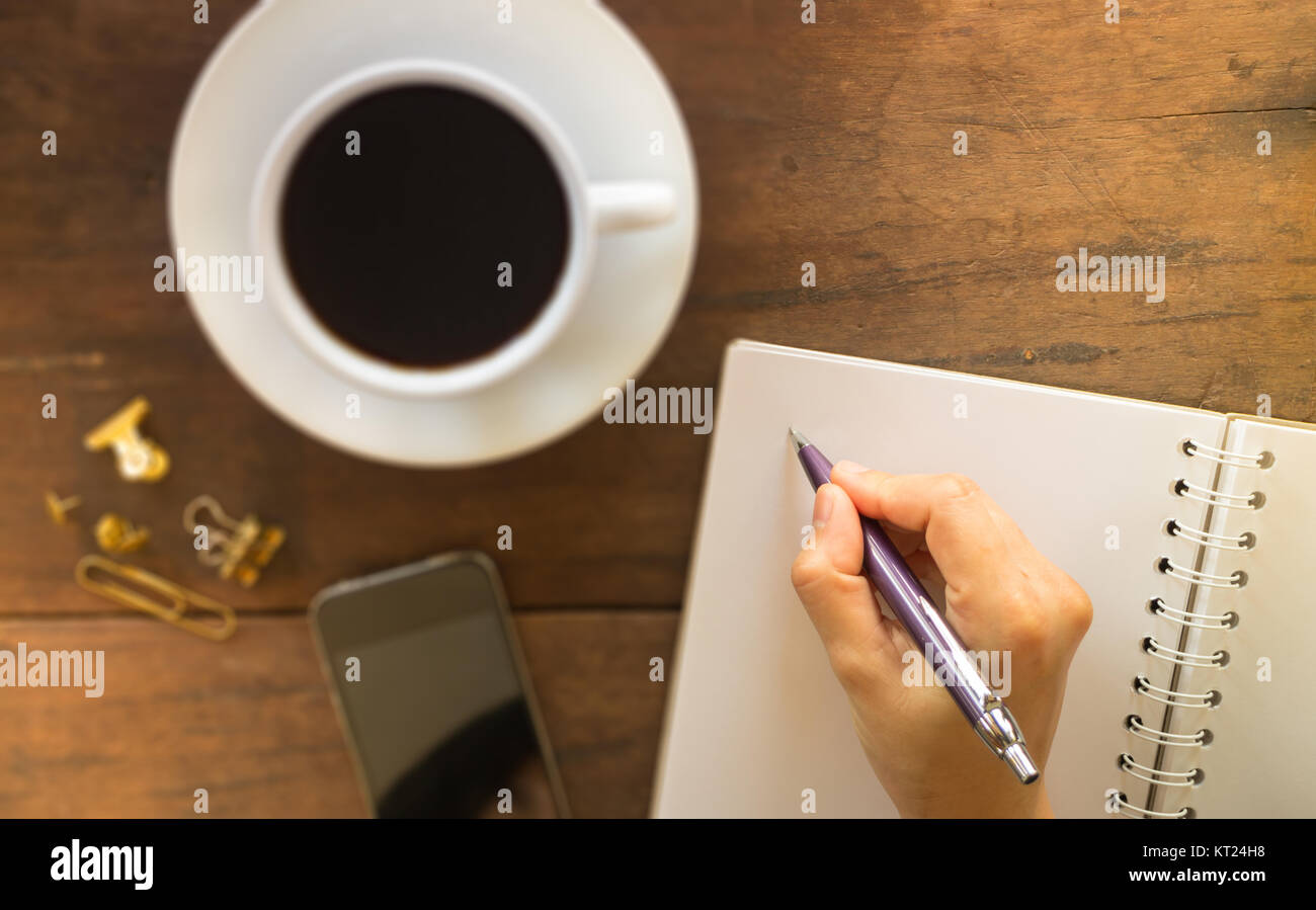 Hot cup of coffee on wooden work table Stock Photo - Alamy