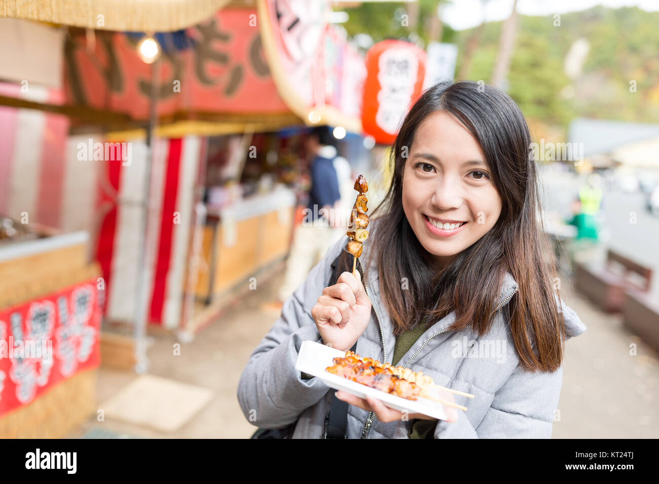 Woman enjoy street snack Stock Photo - Alamy