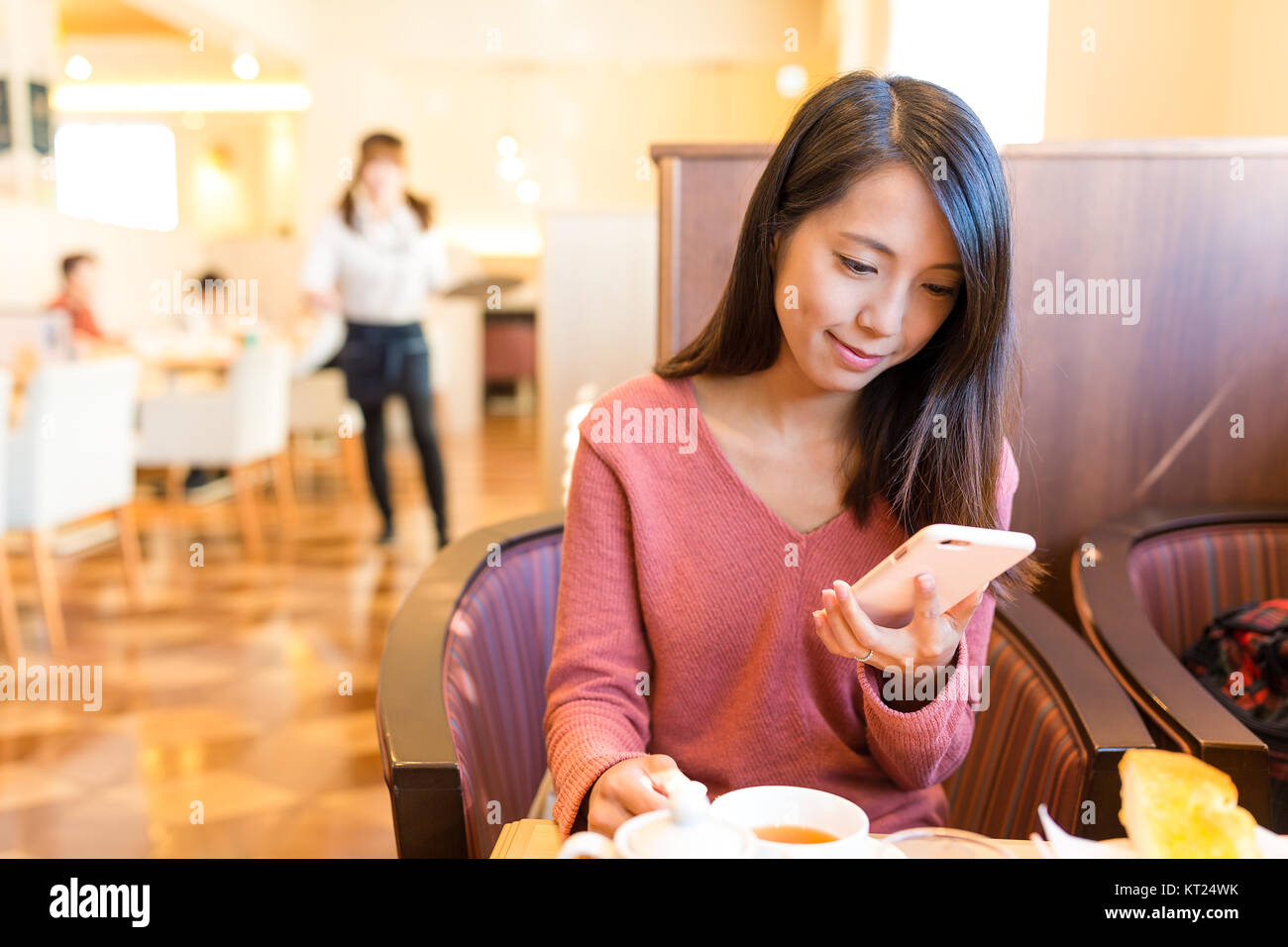 Woman using cellphone in coffee shop Stock Photo - Alamy