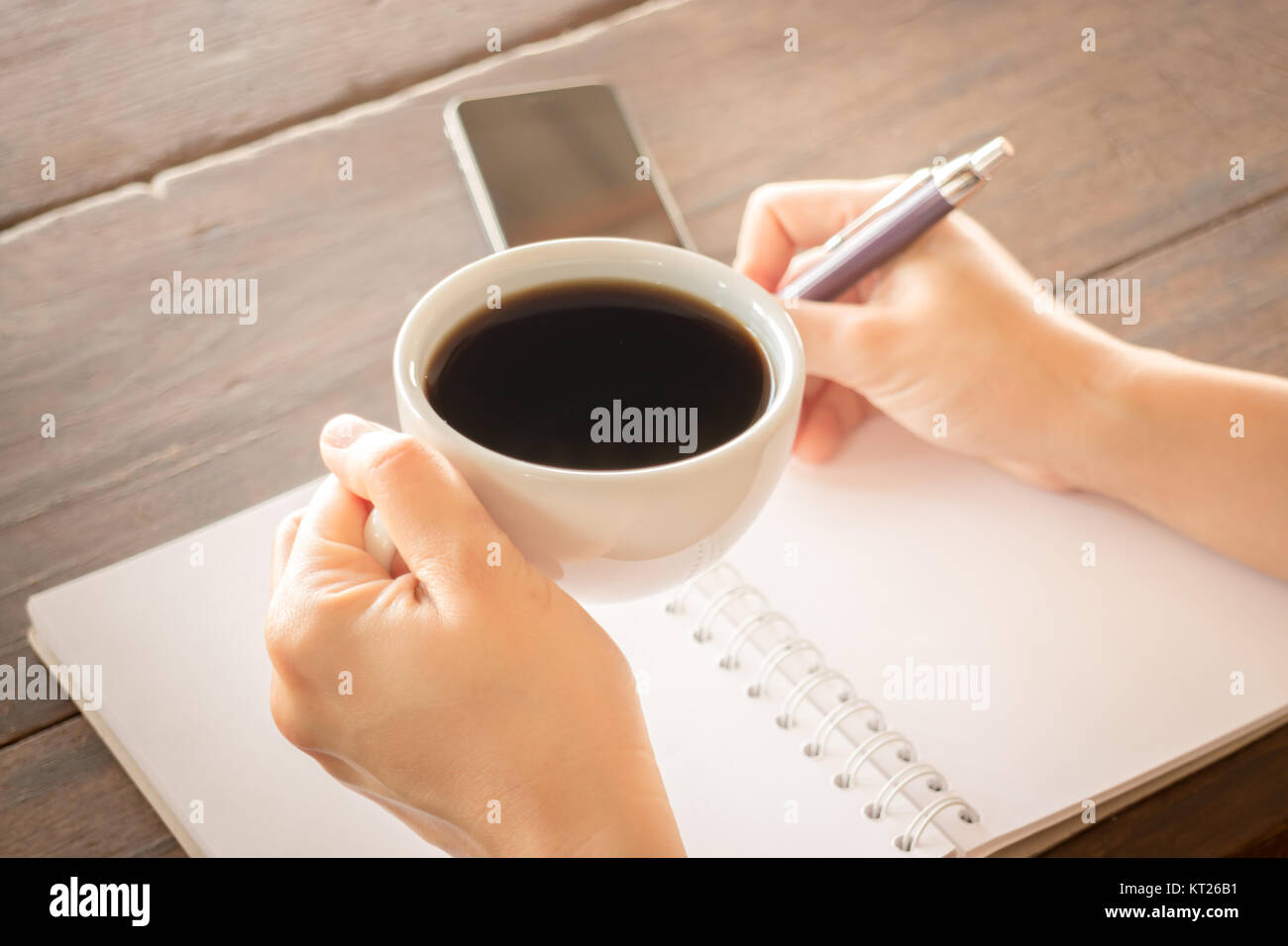 Hand on coffee cup and writing Stock Photo - Alamy