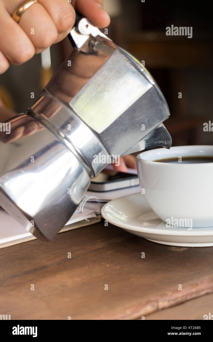 Hand on traditional italian moka pot Stock Photo - Alamy