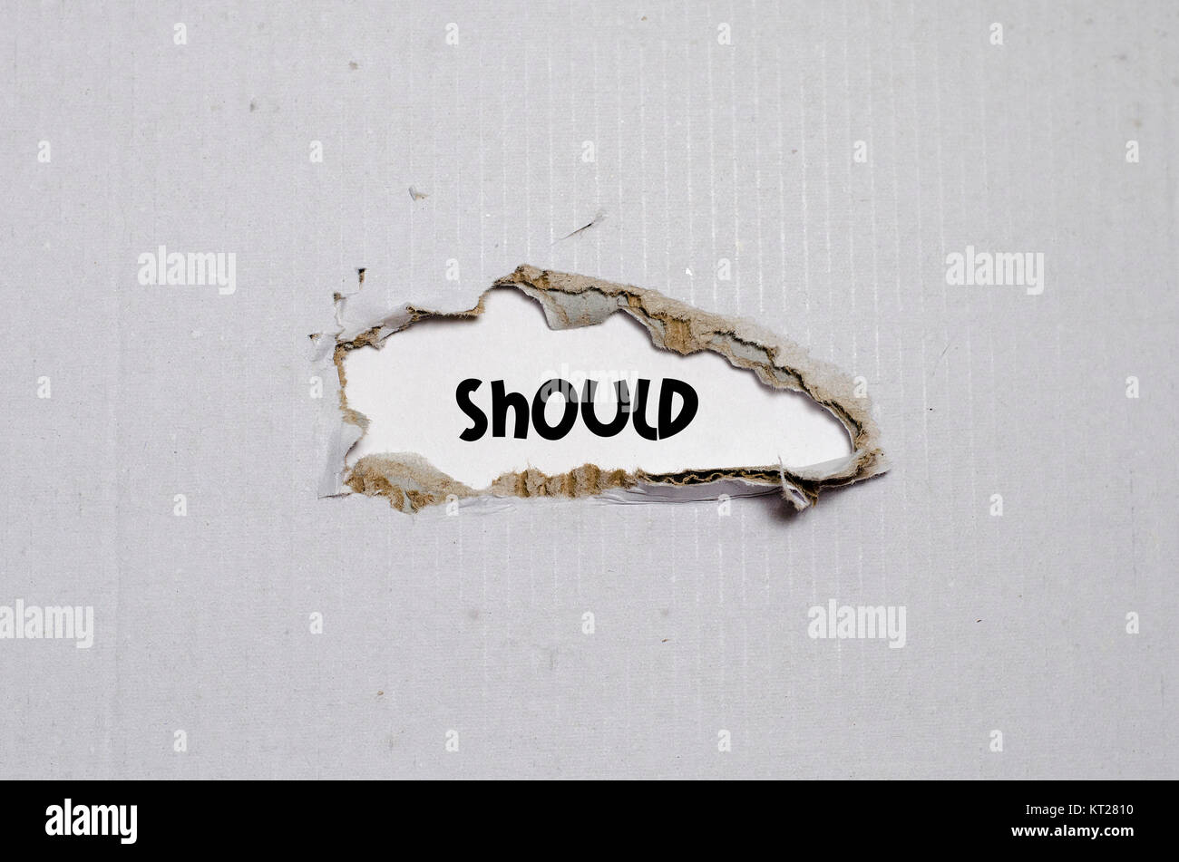 The word should appearing behind torn paper Stock Photo - Alamy