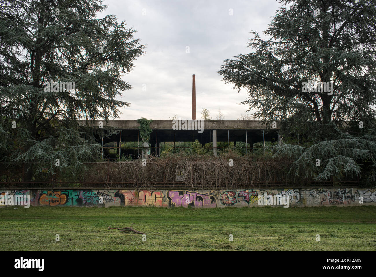 Front view of an old abandoned textile factory with an old chimney ...