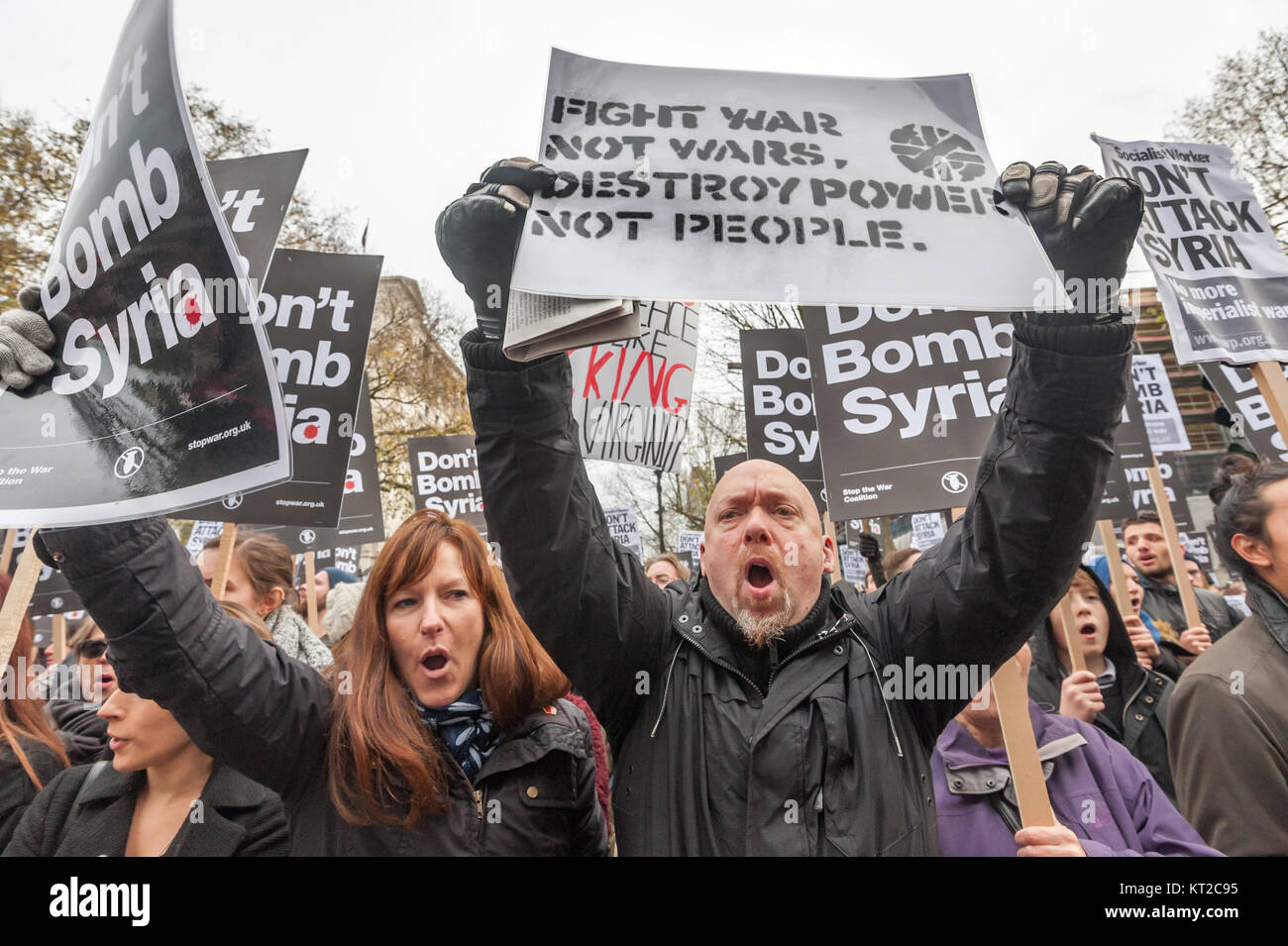 A man holds up a poster 'Fight War Not Wars, Destroy Power Not People ...
