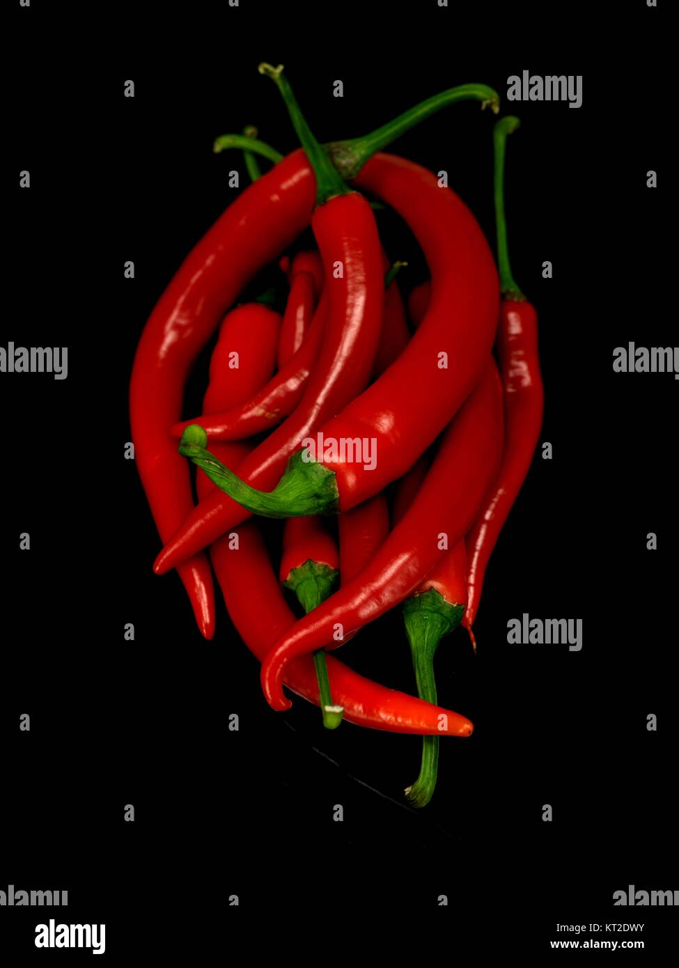 Red chilli peppers isolated against a black background Stock Photo - Alamy