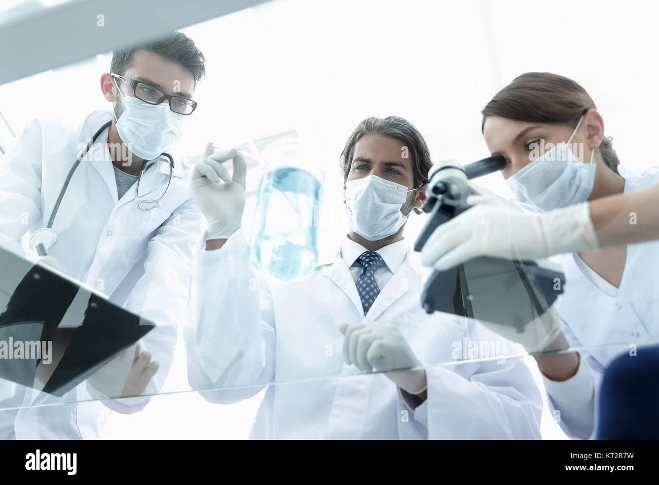 young scientists working with a microscope and test tubes Stock Photo ...