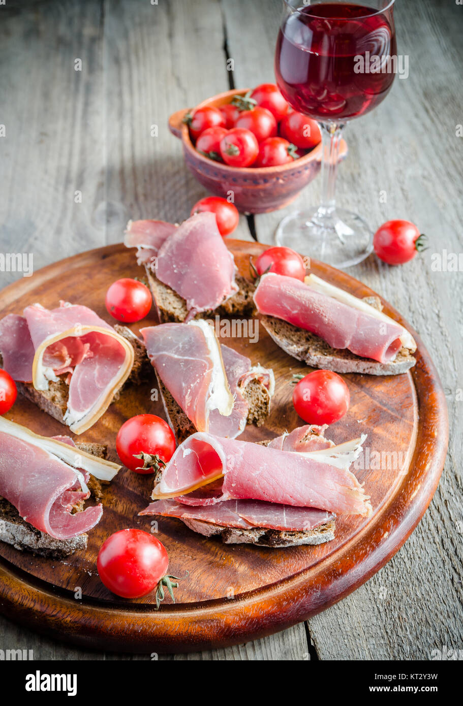 Sandwiches with italian ham on the wooden board Stock Photo - Alamy