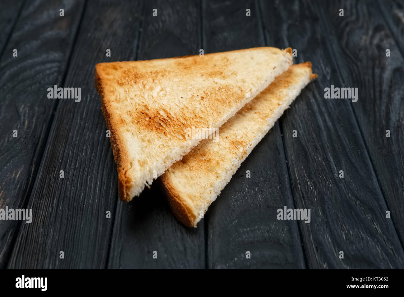 Two pieces of toast bread on dark wooden table. Top view Stock Photo ...