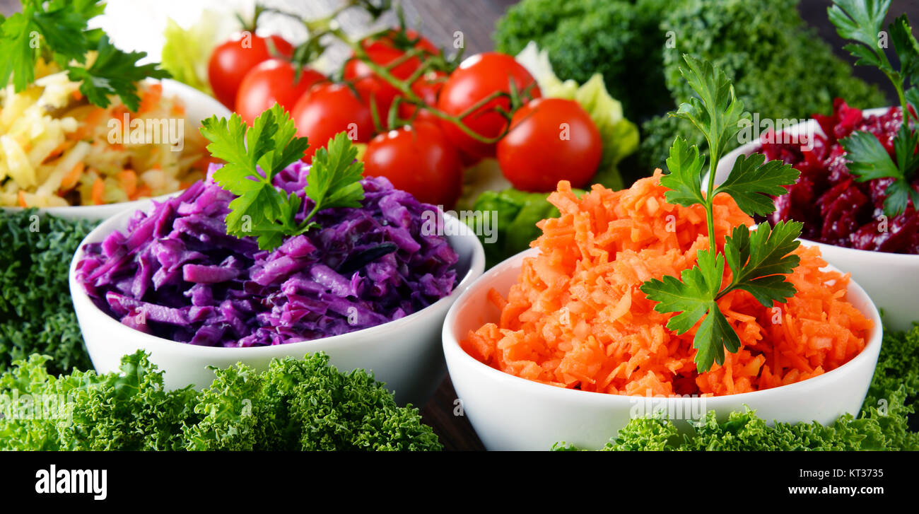 Composition with four vegetable salad bowls on wooden table Stock Photo ...