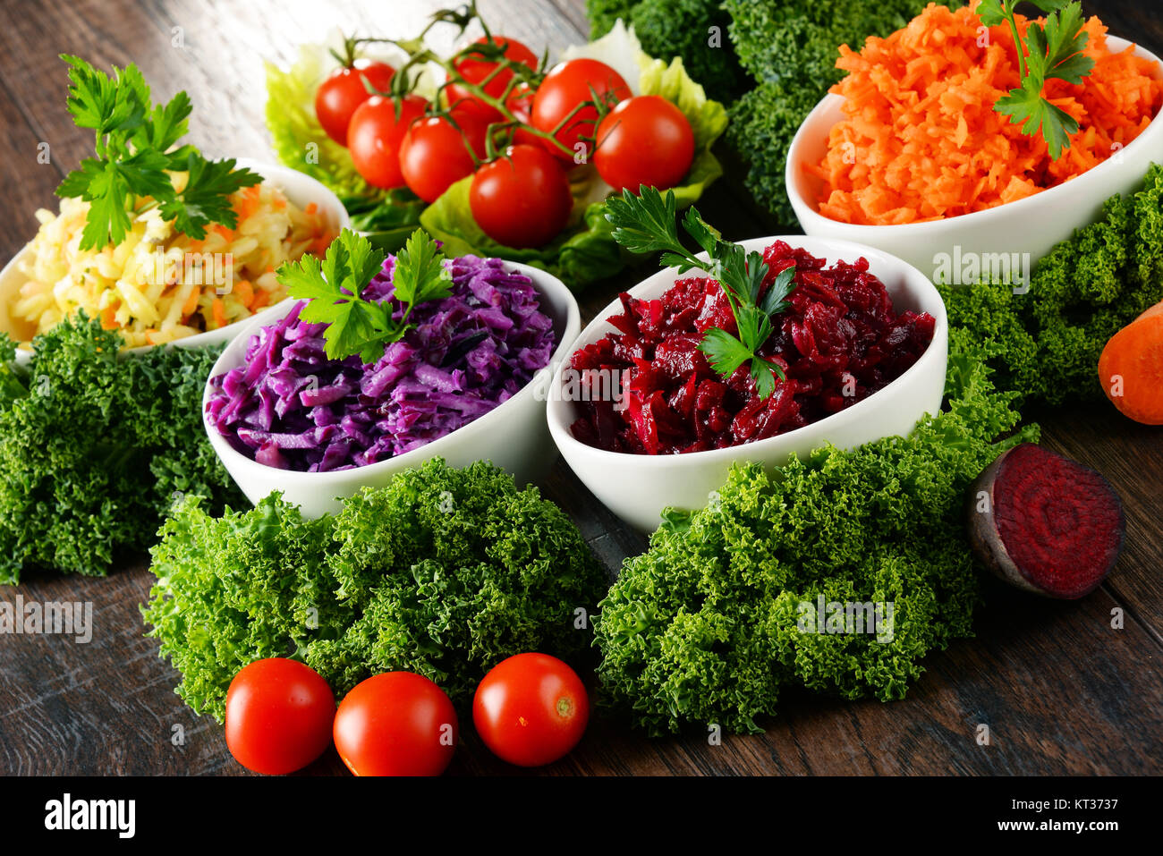 Composition with four vegetable salad bowls on wooden table Stock Photo ...