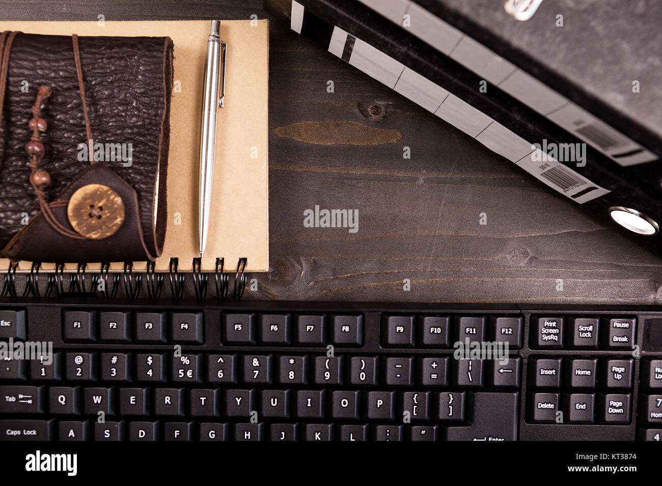Top view of a vintage notebook next to a pile of folders and a computer ...