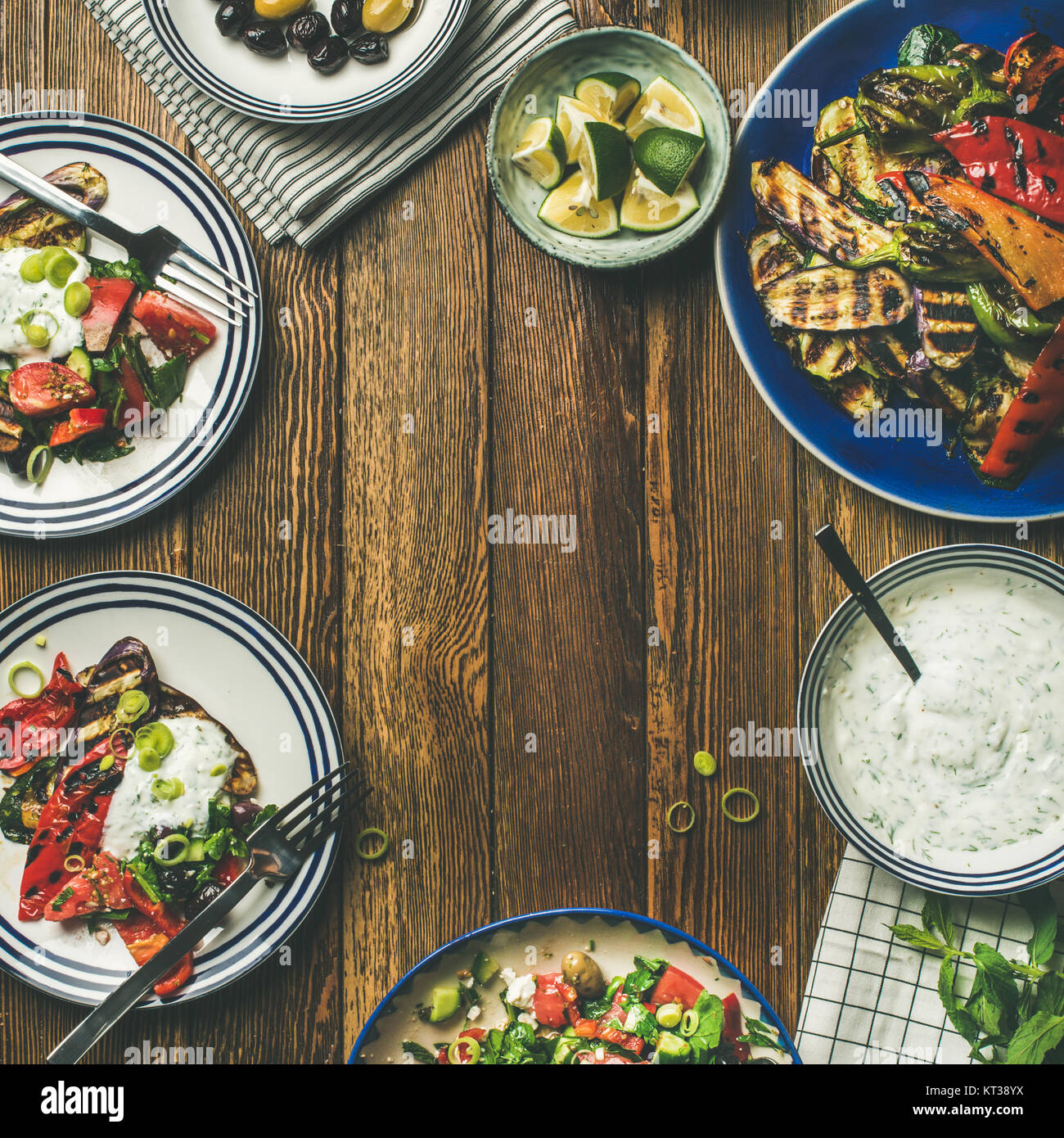 Flat-lay of healthy dinner table setting. Fresh salad, grilled ...