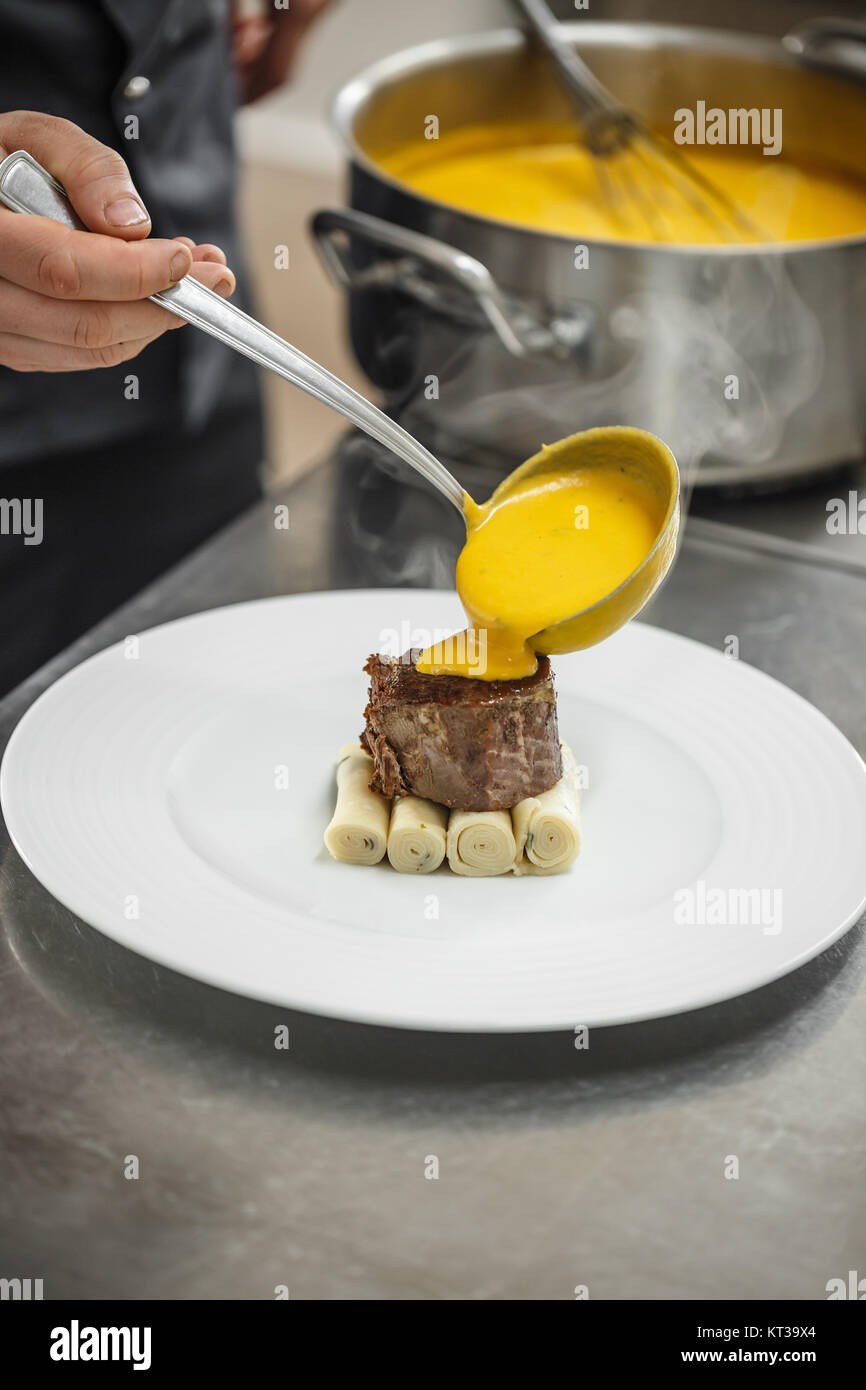 Chef pouring gamy sauce Stock Photo - Alamy