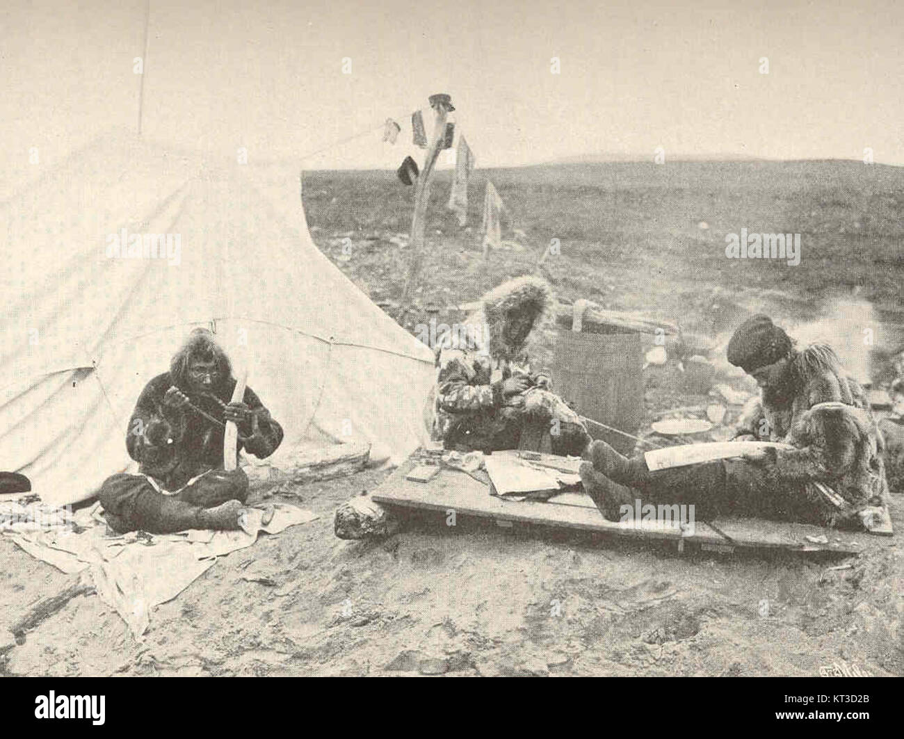 This photograph captures an Eskimo family working on traditional crafts ...