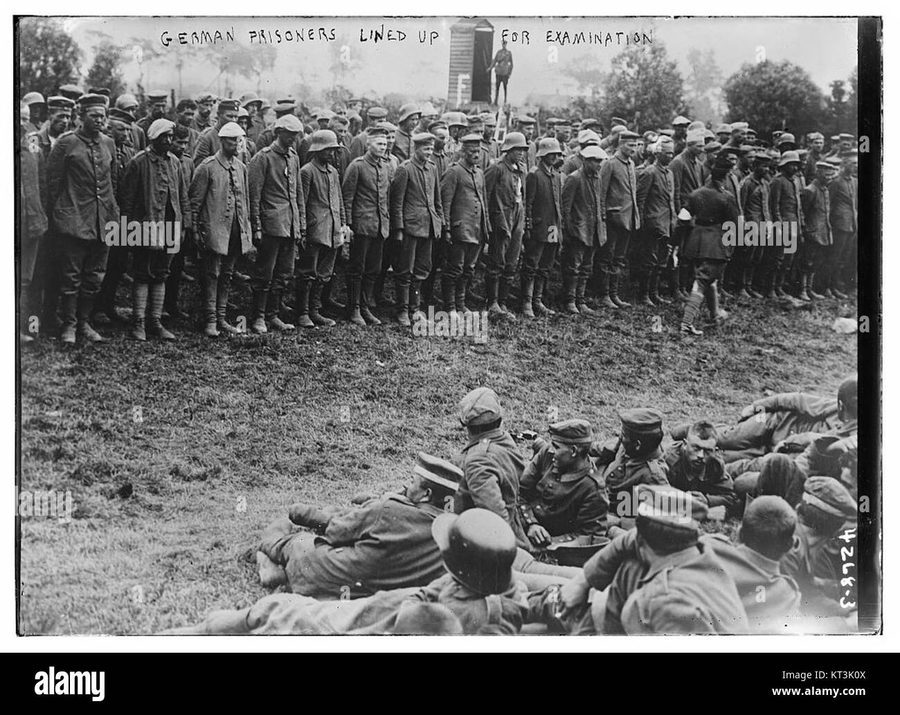 This image shows a group of German prisoners lined up for examination ...