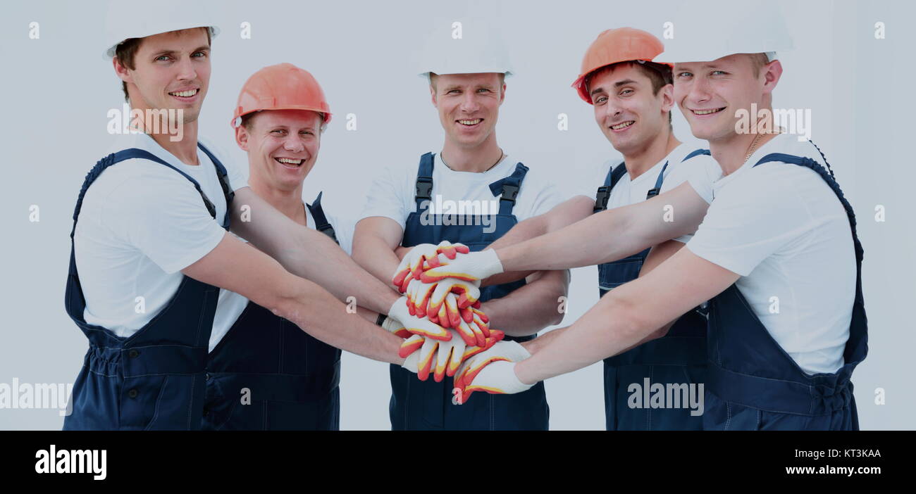 Team of builders joining hands in circle Stock Photo - Alamy