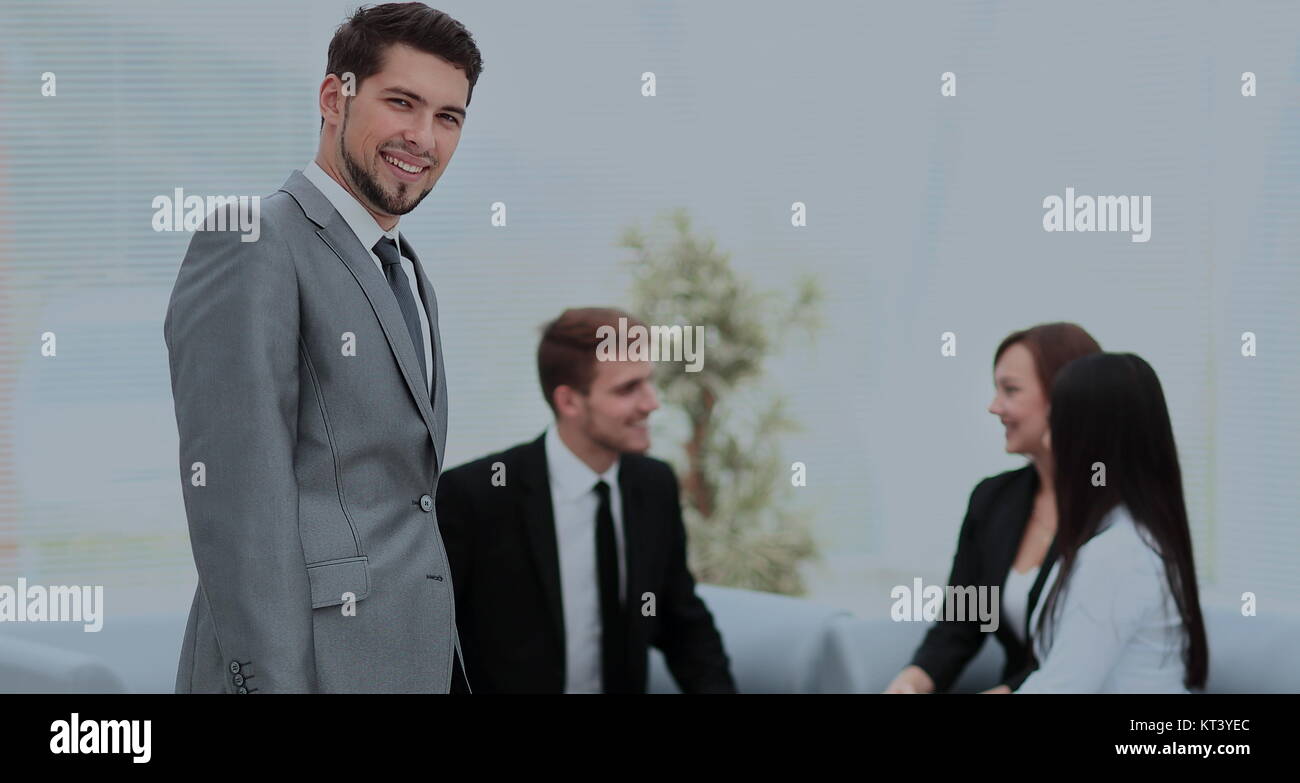 Successful business man standing with his staff in background at Stock ...