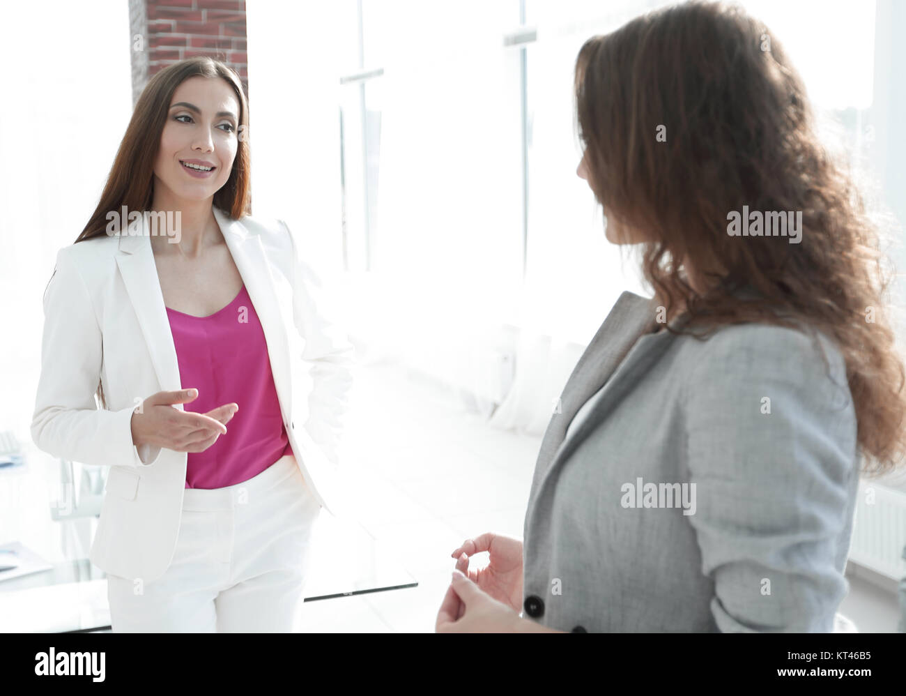 female Manager talking to a colleague Stock Photo - Alamy