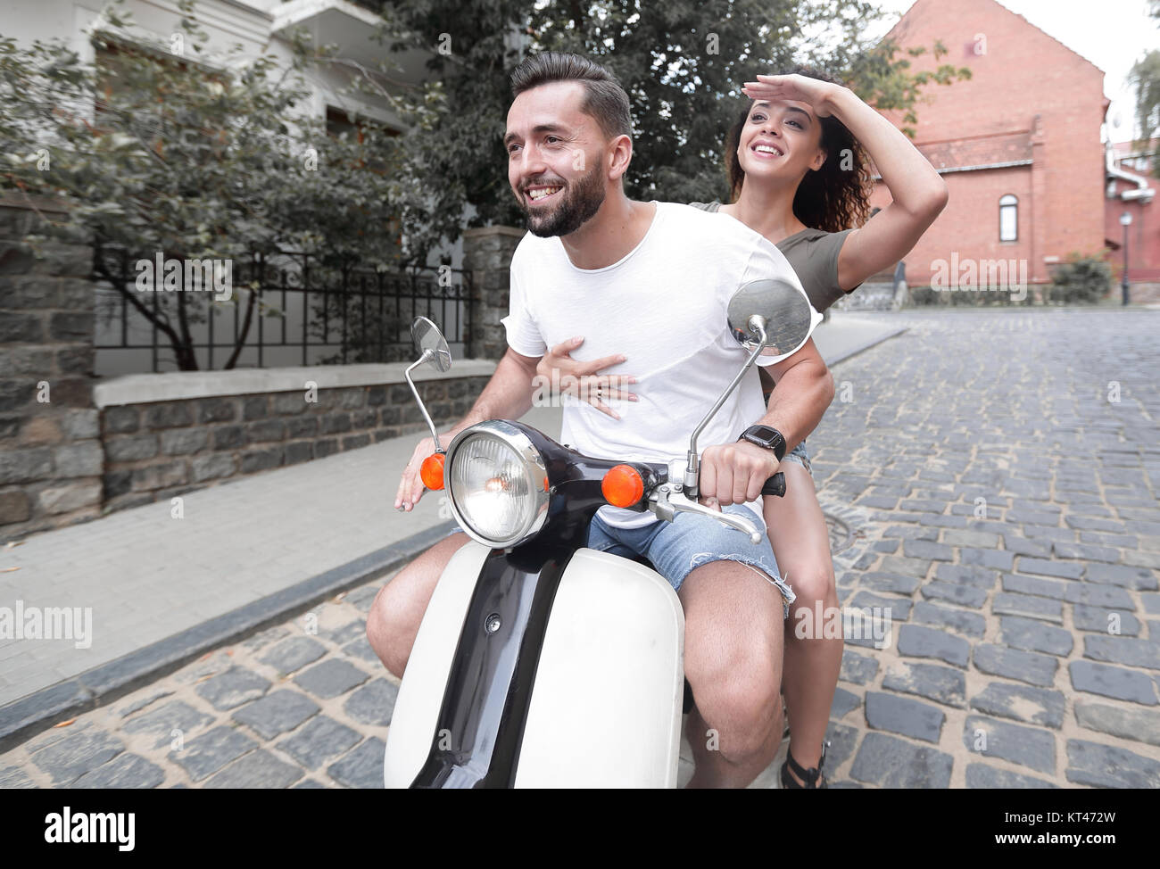Young couple riding motor scooter in city Stock Photo - Alamy