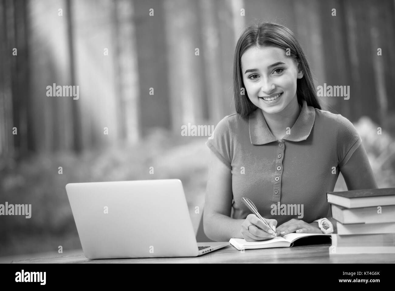 Young woman using laptop computer and smart phone. Beautiful student ...