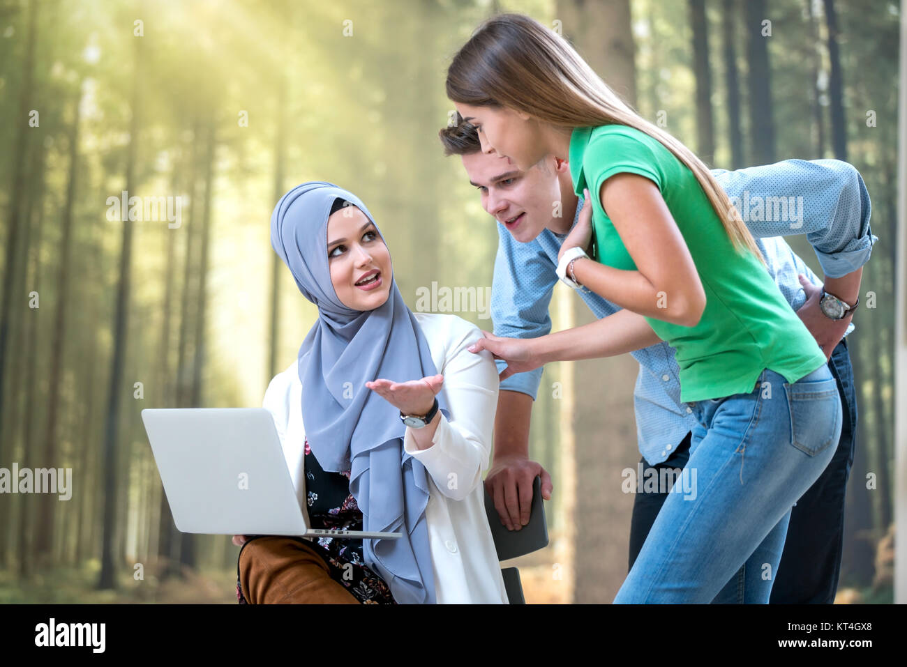 diverse college students using laptop and talking, learning exchanging ...