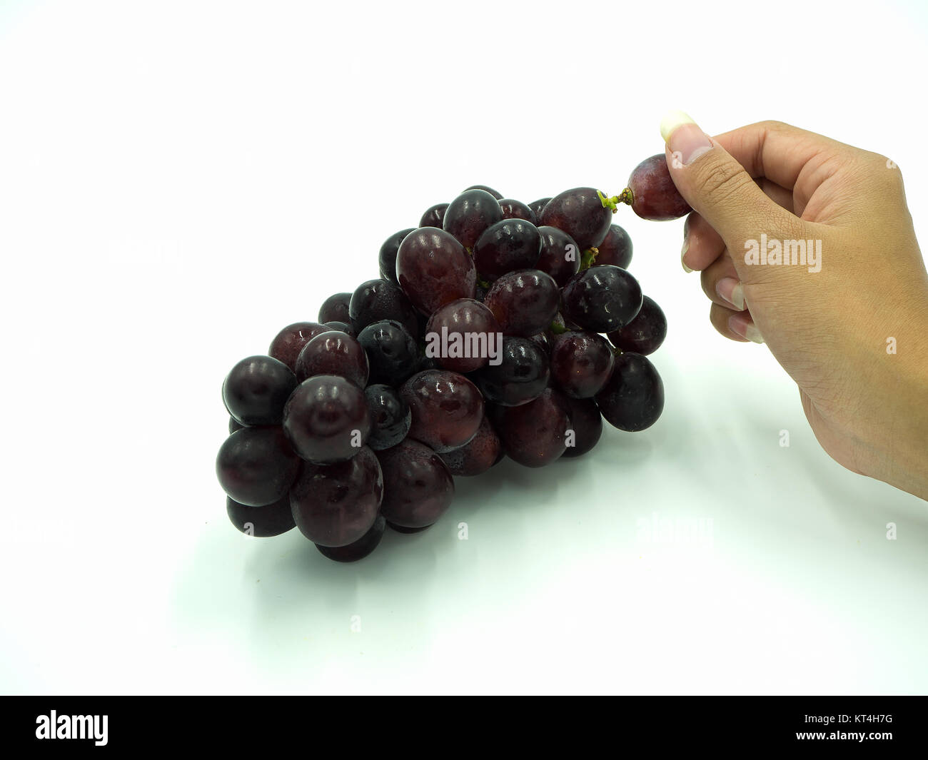 Woman's hand holding red grape on isolate white background Stock Photo ...