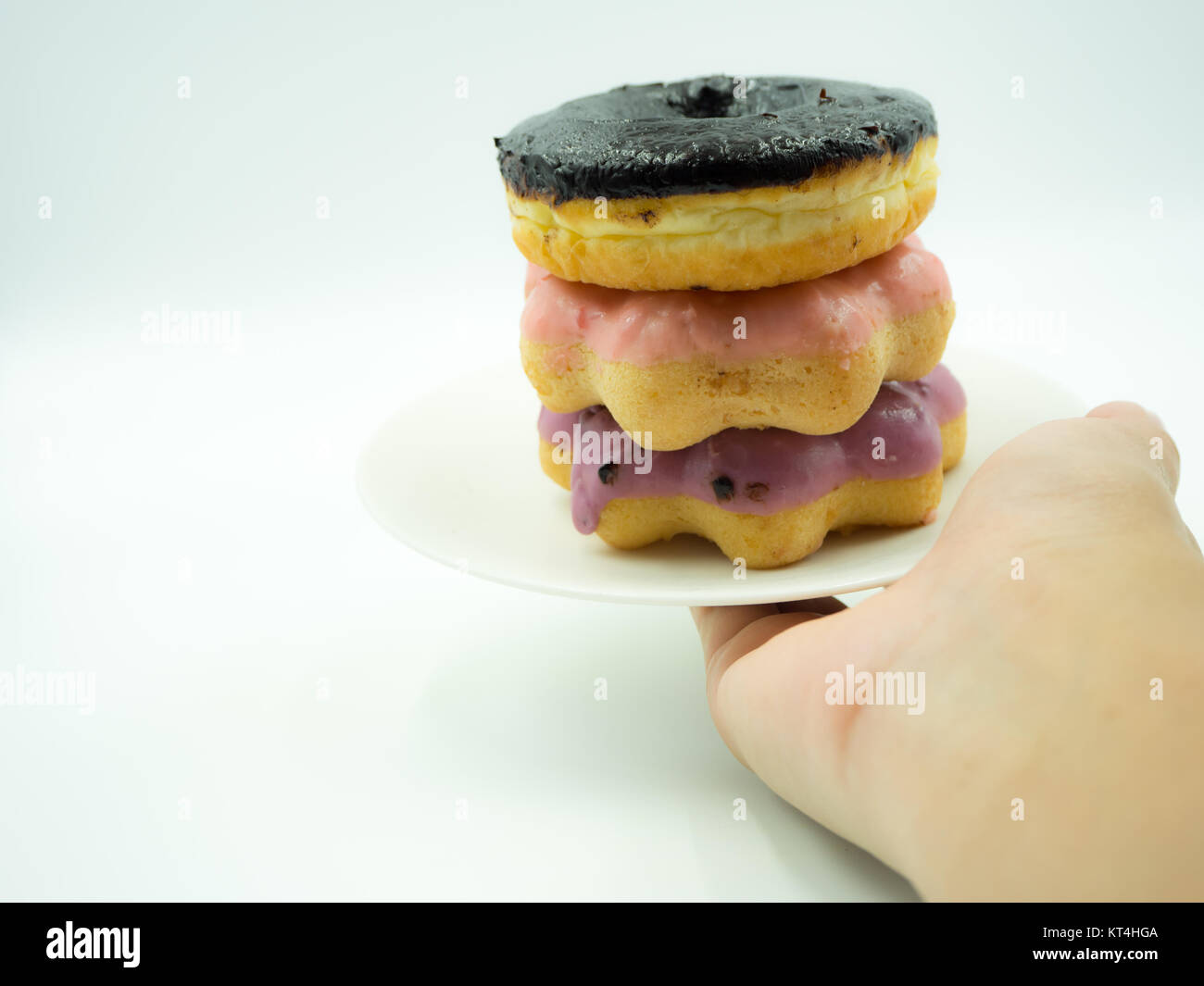 Woman's hand holding donut on white background Stock Photo - Alamy