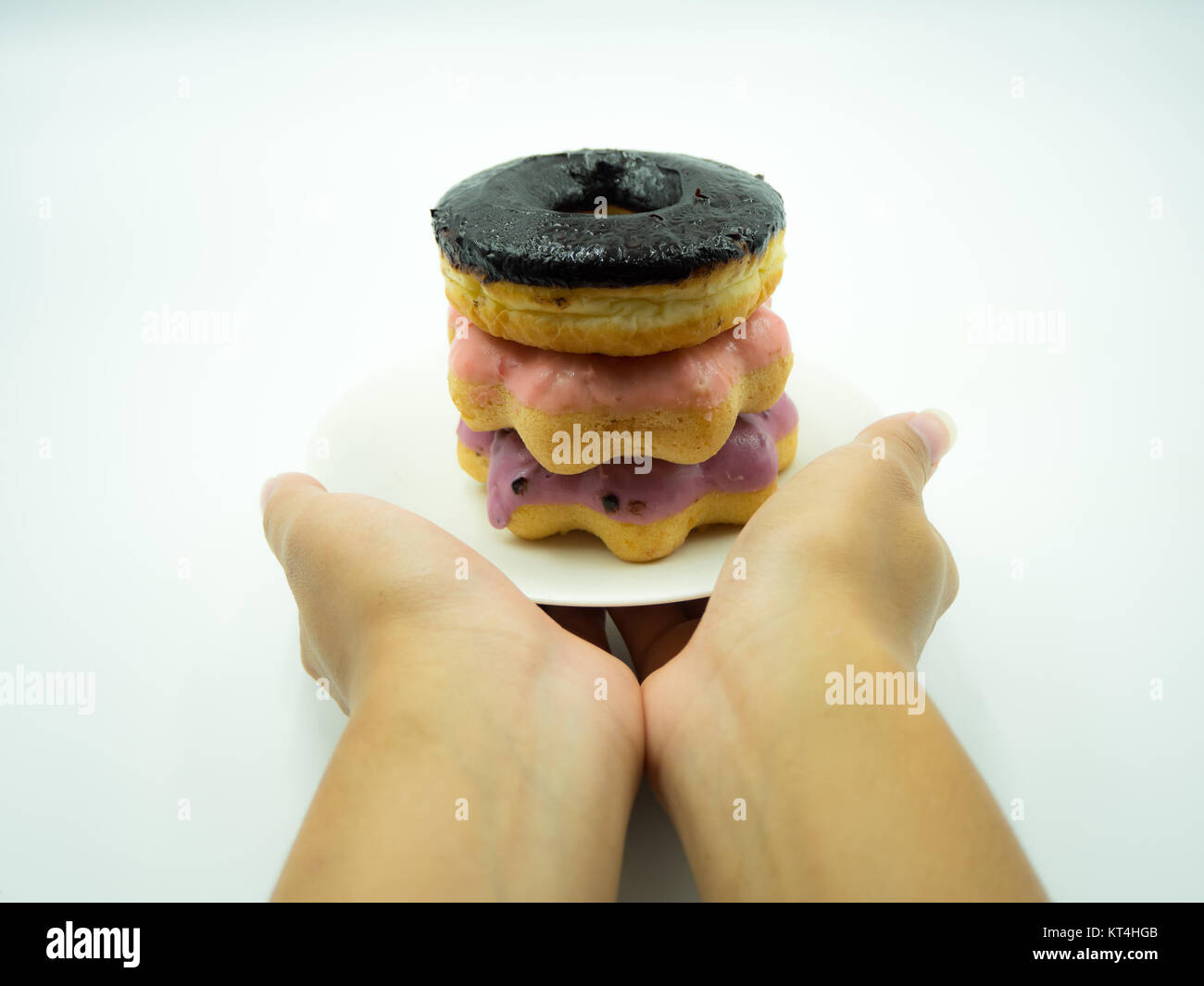 Woman's hand holding donut on white background Stock Photo - Alamy