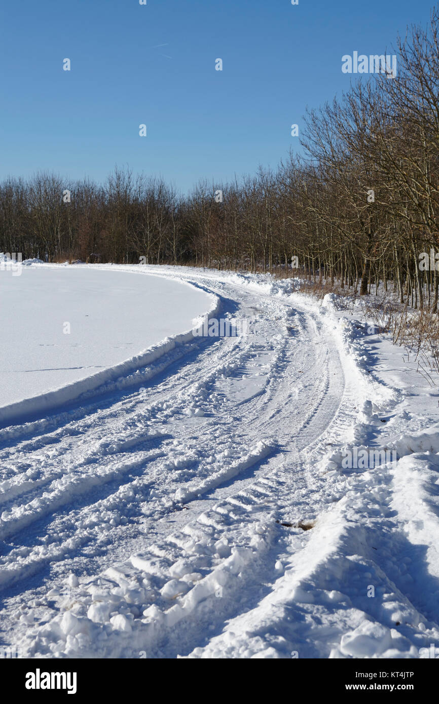 A snowscape with some skid marks in the snow at a sunny day with a ...