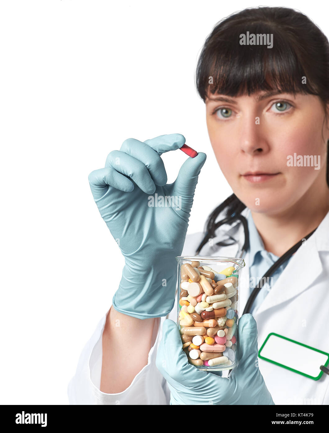 Female doctor or nurse with glass full of pills looks at the camera ...