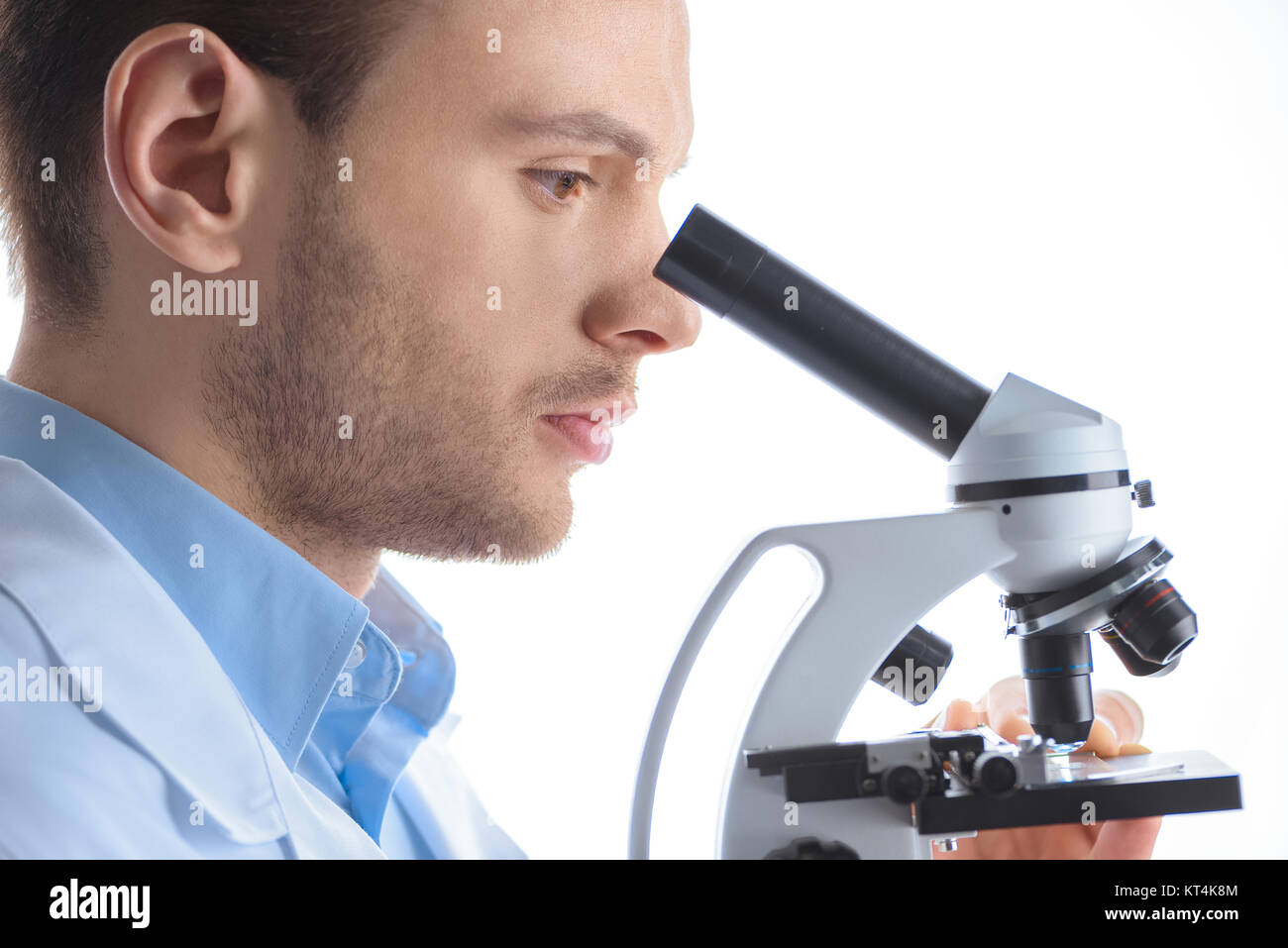 side view of concentrated man scientist looking through microscope on ...