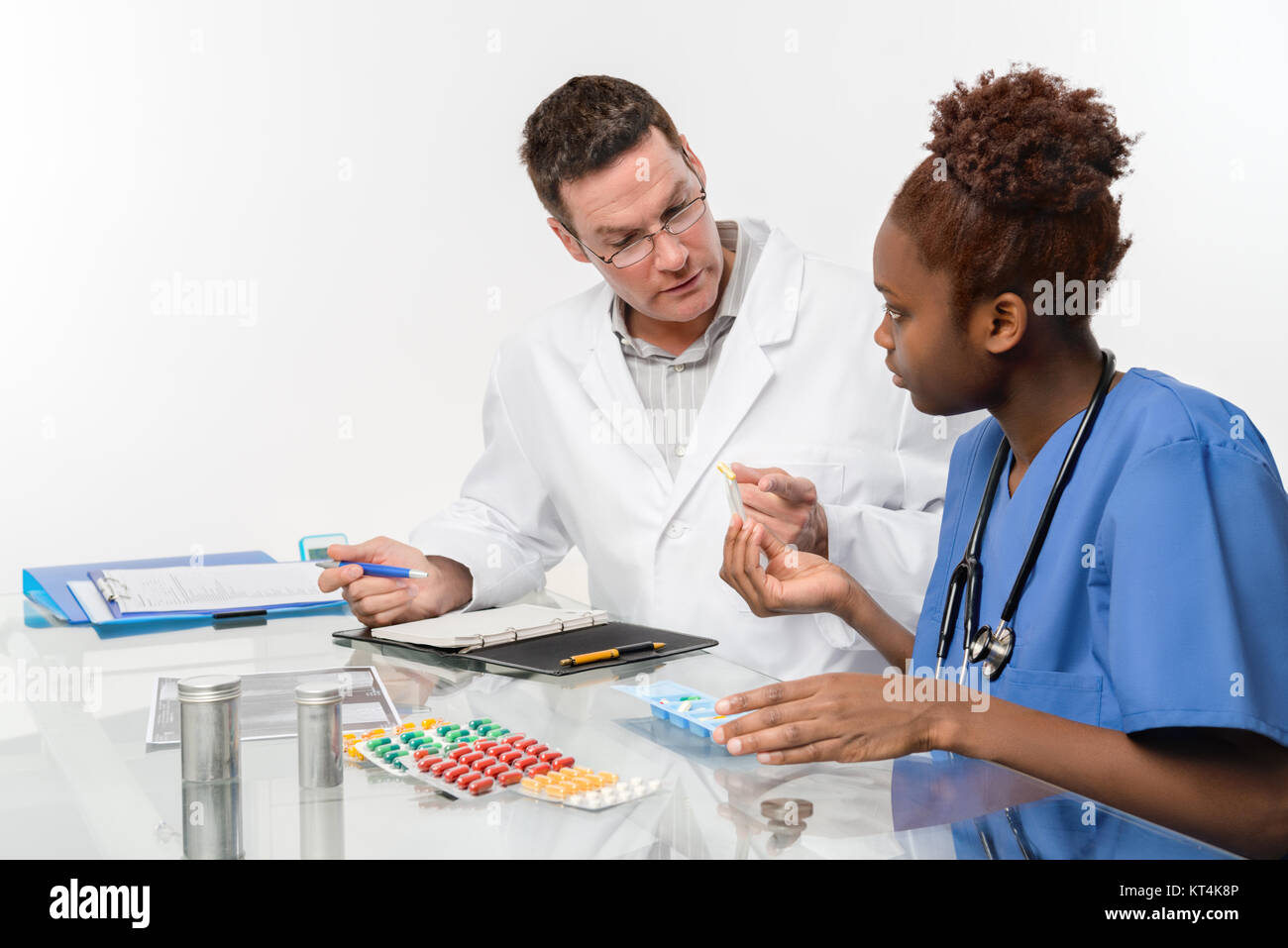 Doctor explains to the nurse appropriate medications for his patient ...