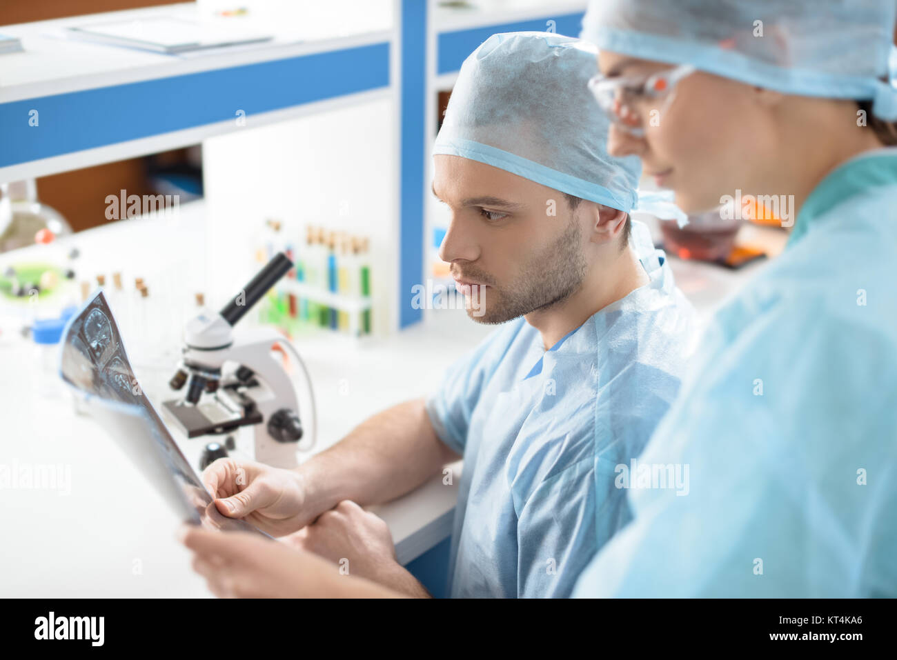 side view of surgeons in medical uniforms analyzing x-ray image in ...