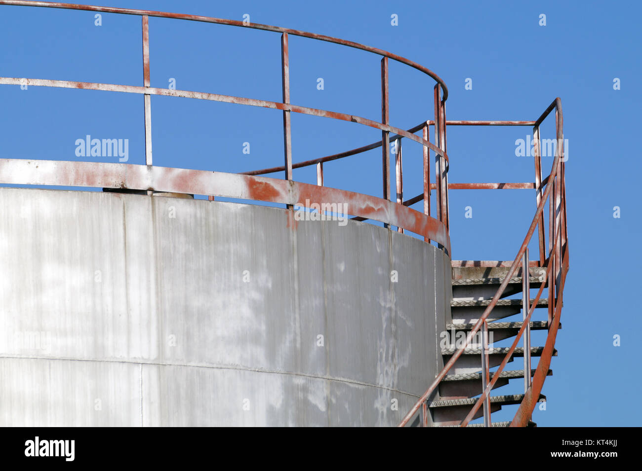A stairway casts a heavy on an old silver storage tank. Stairs cast ...