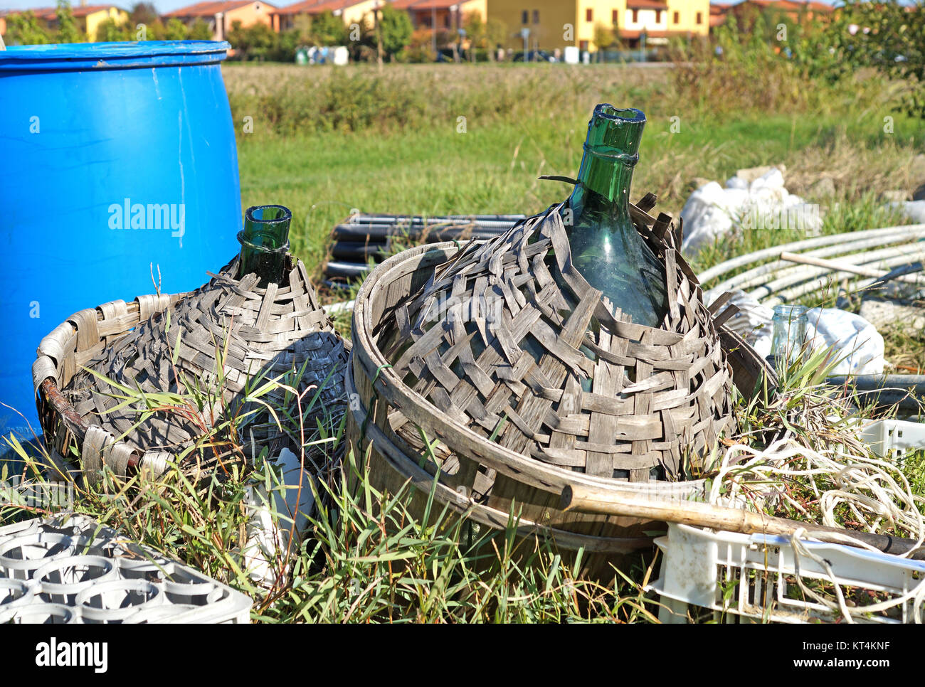 Old demijohn glass wrapped in wicker abandoned Stock Photo - Alamy