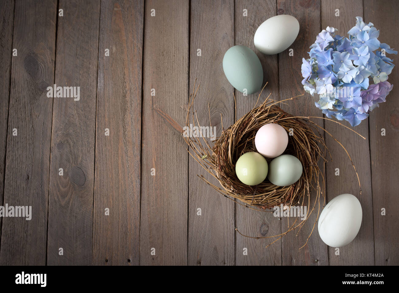 Pastel colored easter eggs in a nest with blue hydrangeas on a shabby wooden table Stock Photo ...