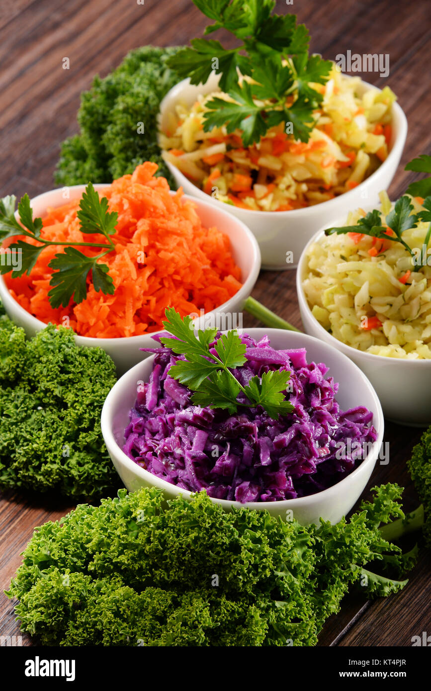 Composition with four vegetable salad bowls on wooden table Stock Photo ...