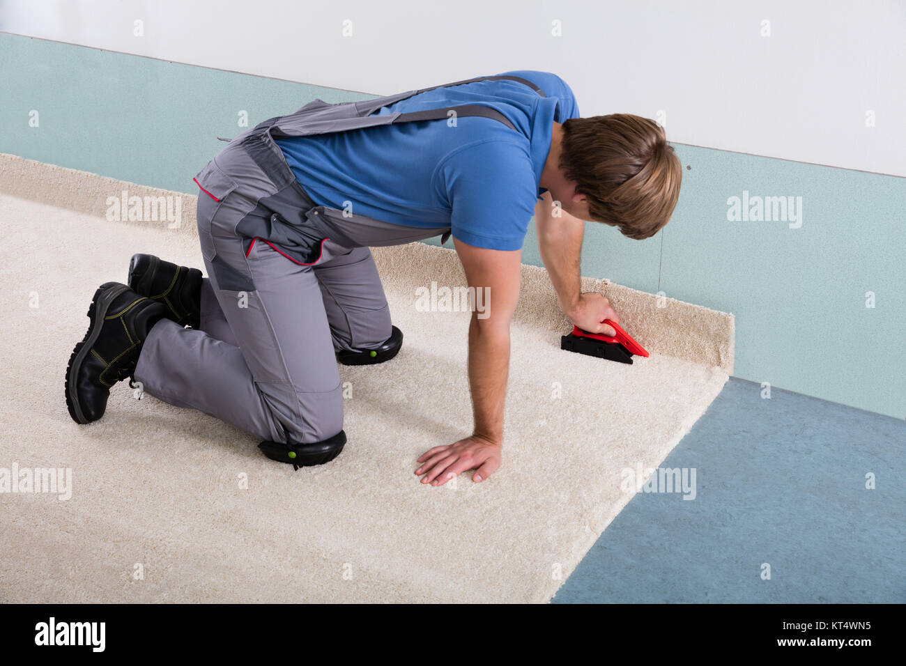 Male Craftsman Fitting Carpet Stock Photo - Alamy
