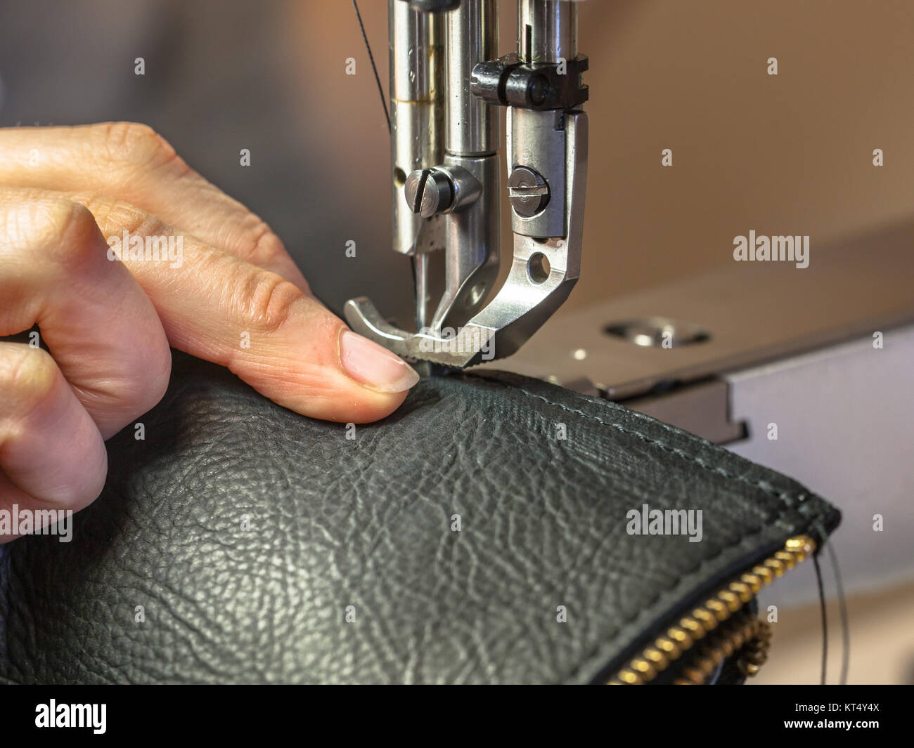 Sewing machine in action in workshop operated with hands working on ...