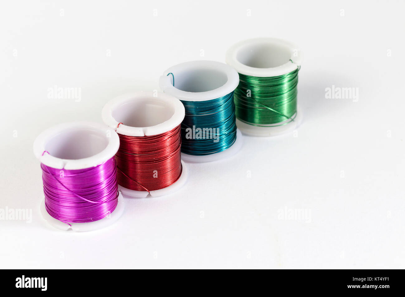 4 colorful wire rolls in front of white background Stock Photo - Alamy