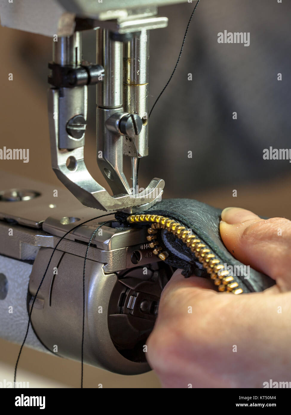 Professional Sewing machine in action in workshop operated with hands ...