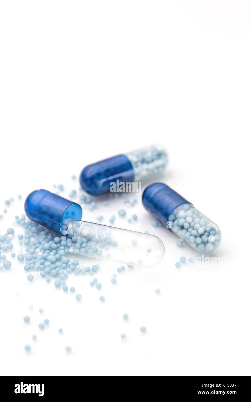 Blue capsules and pills background Stock Photo - Alamy