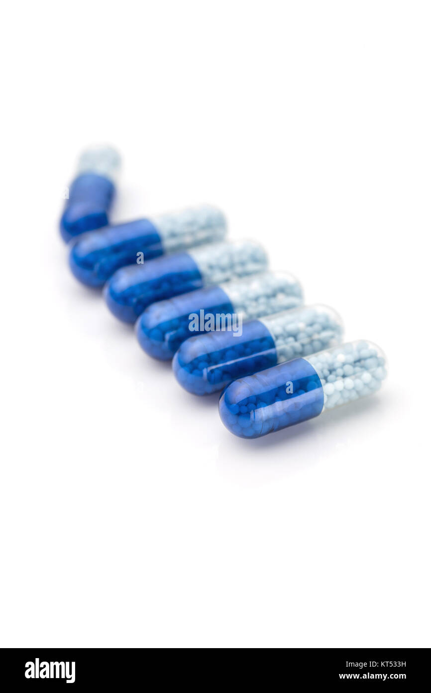 Blue capsules and pills background Stock Photo - Alamy