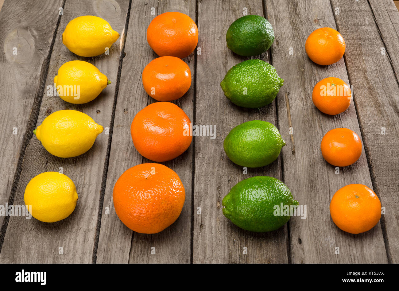 Close-up view of fresh healthy citrus fruits in rows on wooden table ...