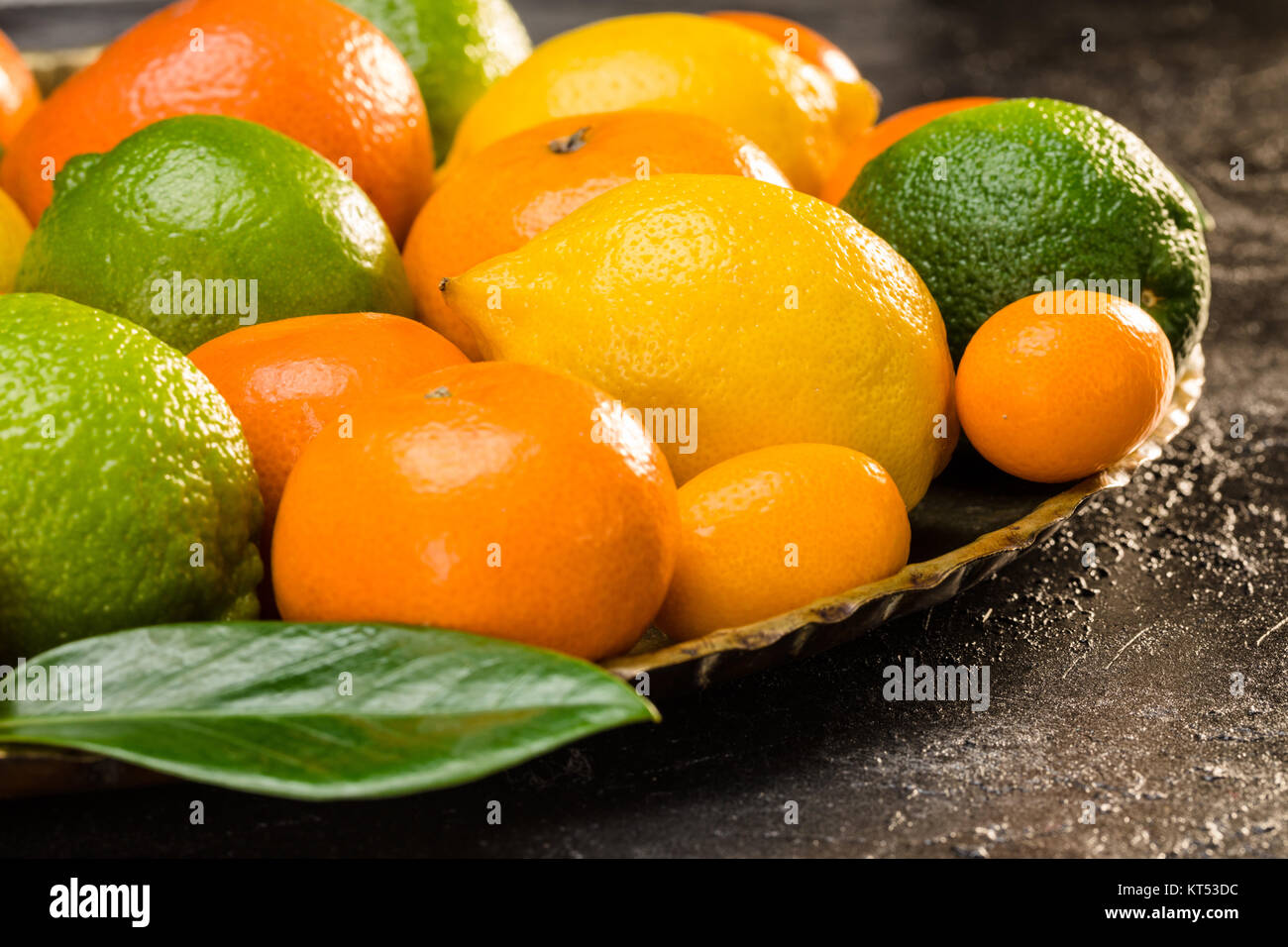 side view of fresh whole citrus fruits and leaf on plate Stock Photo ...